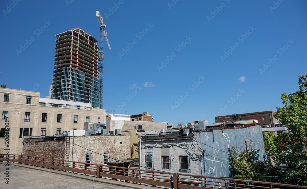 Brand new construction of a high rise building towering over old city ...