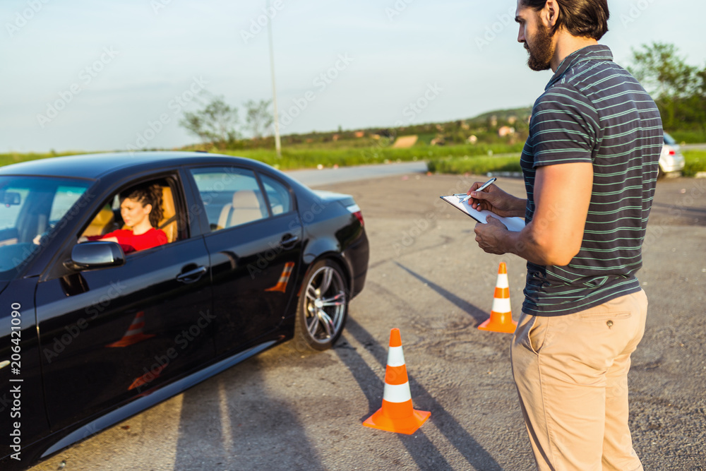 Driving school or test. Beautiful young woman with instructor learning ...