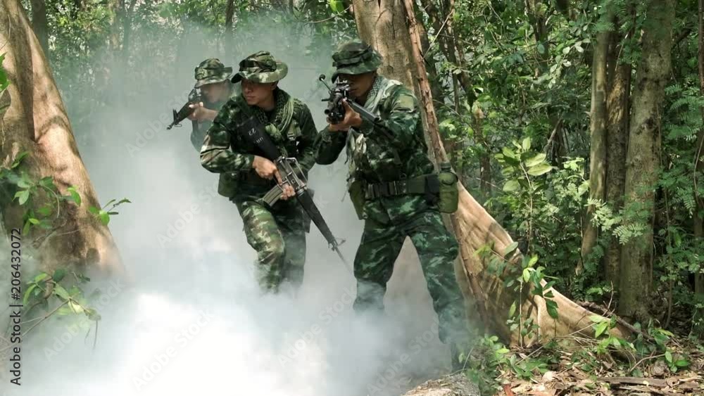 Slow motion of soldiers aiming their assault rifles in jungle. Chinese ...