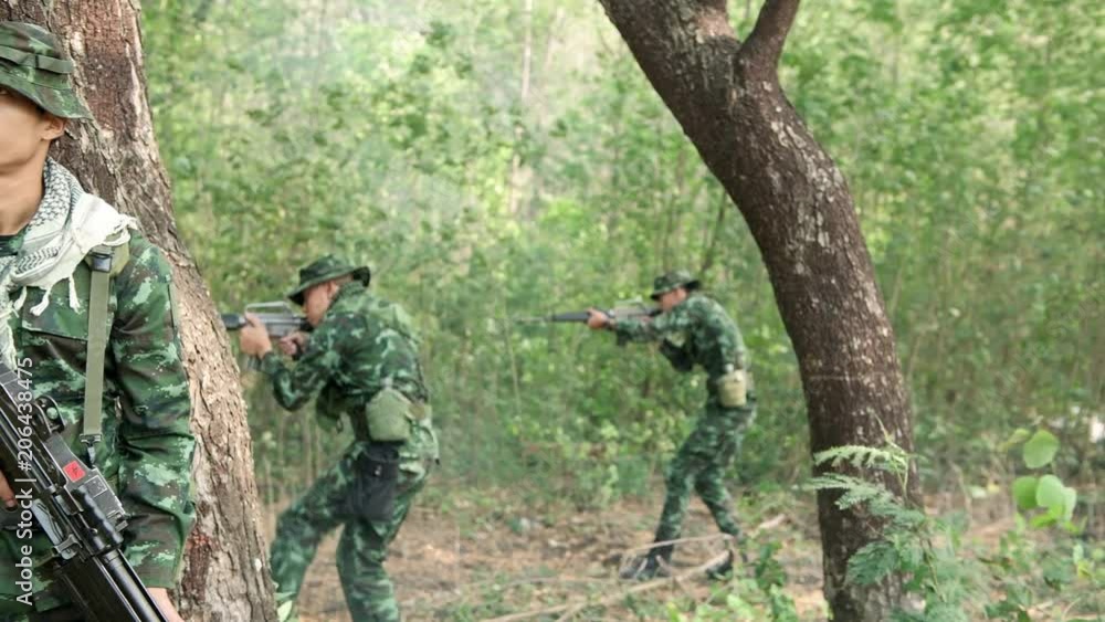 Soldiers aiming their assault rifles in jungle. Chinese soldiers in ...