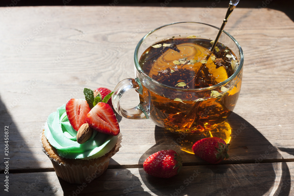 Фруктовые кексы с чашкой черного чая на деревянном фоне Stock-Foto ...