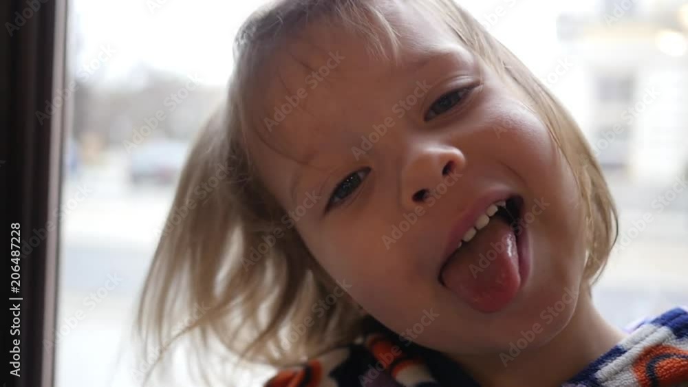 Cute grimace face portrait of a little child girl joyfully show tongue ...