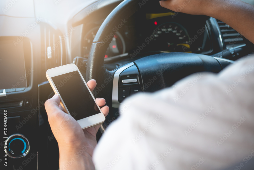 The driver is using mobile while driving to see navigation mapsto the ...