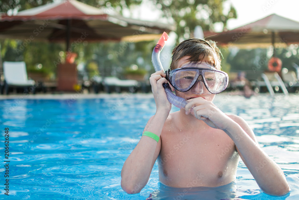 Teenager boy wearing mask swimming in the pool. Happy holiday concept ...