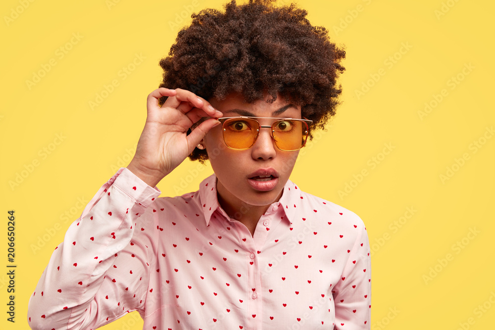 Portrait of good looking stunned puzzled African American female looks ...