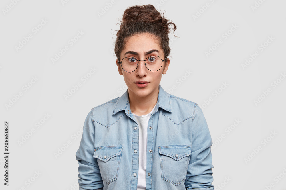 Attractive teenager with dark hair, wears fashionable denim shirt and ...
