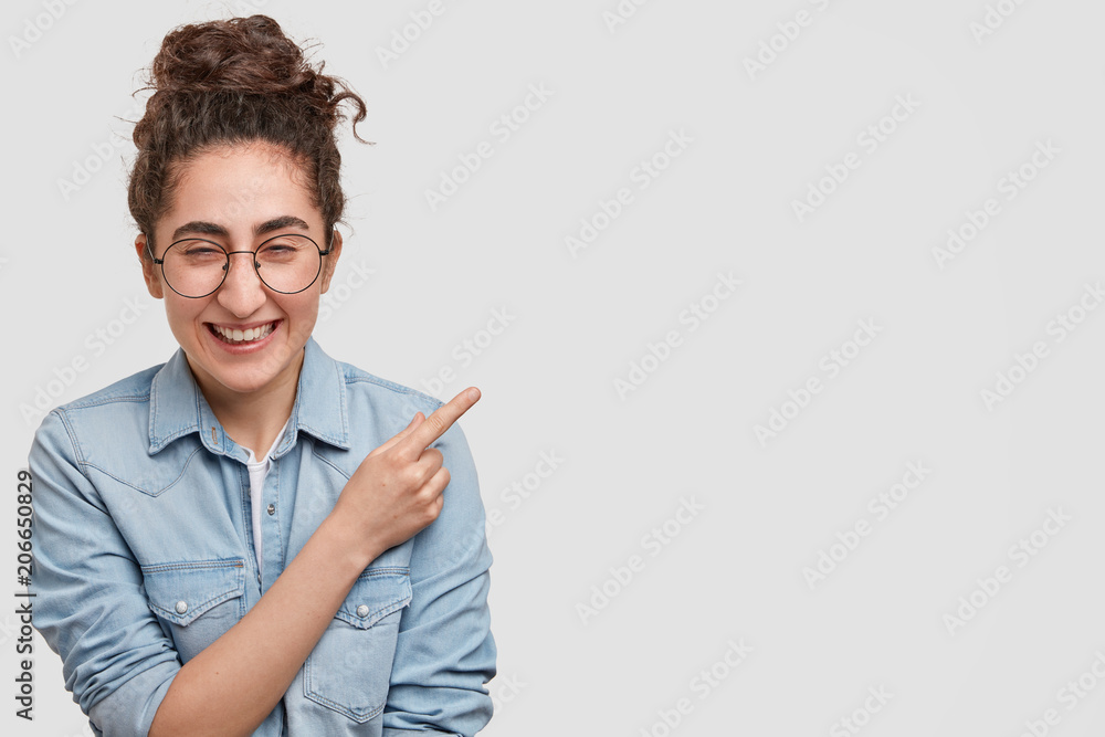 Positive brunette female wonk student has comic expression, giggles at ...