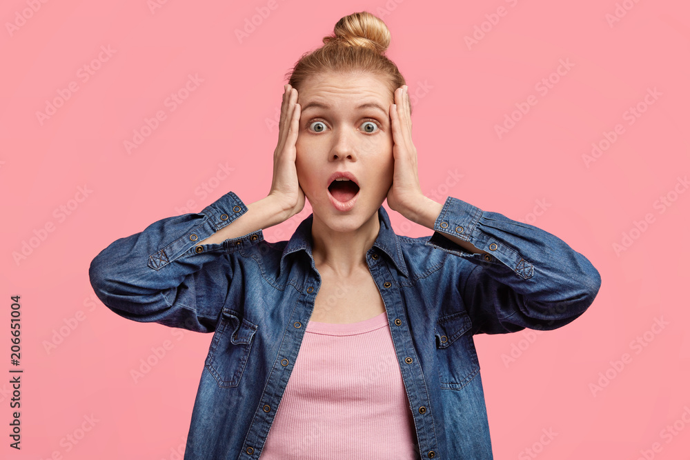 Emotive stupefied young European female keeps mouth widely opened as ...