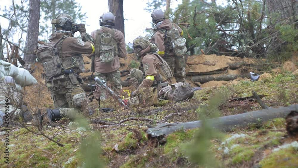 Soldiers in camouflage with combat weapons make their way outside the ...