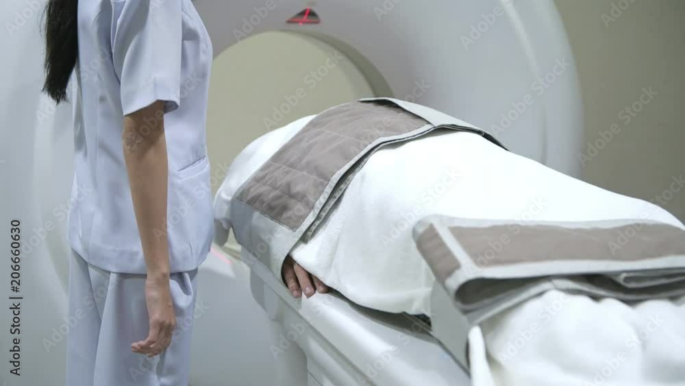 Patient in MRI machine for a CT scan. Senior man cover in blanket going ...