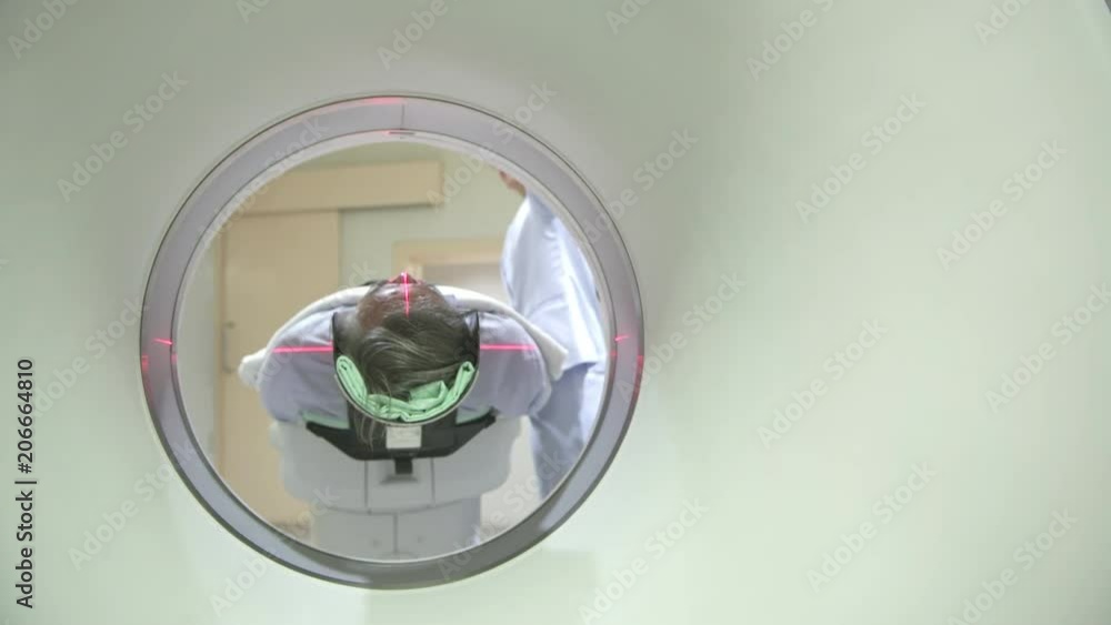 Patient in MRI machine for a CT scan. Senior man cover in blanket going ...