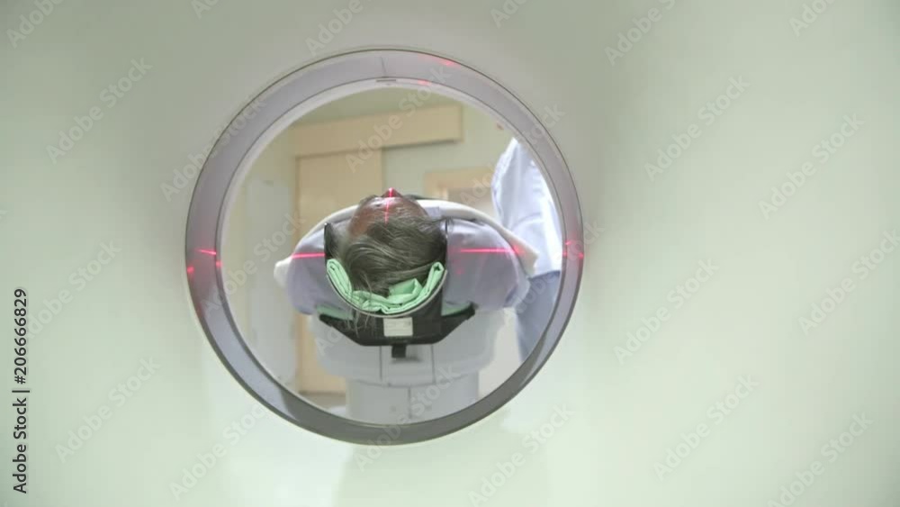 Patient in MRI machine for a CT scan. Senior man cover in blanket going ...