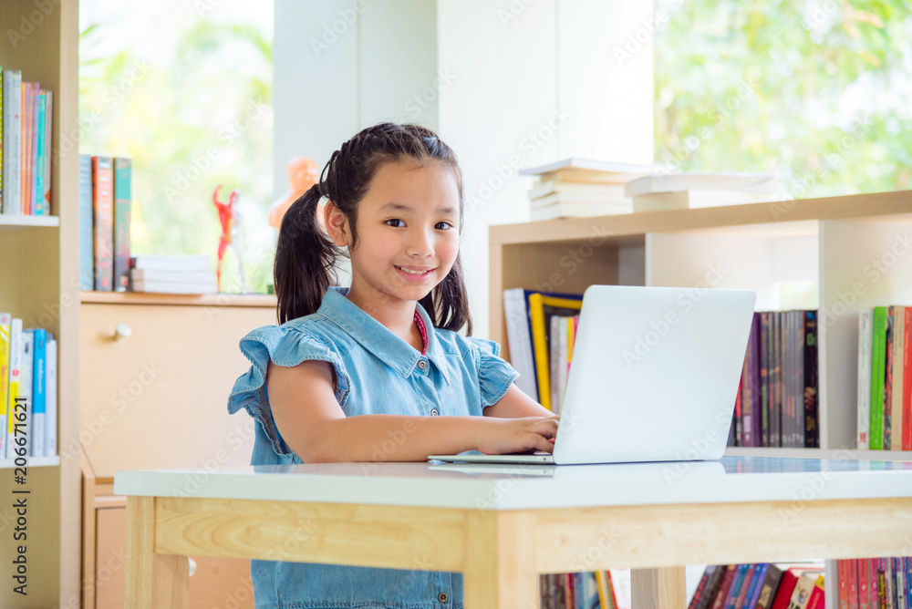 Young asian girl using laptop computer in library Stock Photo | Adobe Stock
