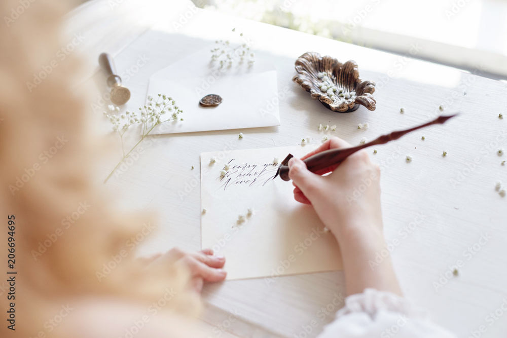 Girl writes a letter to her beloved man sitting at home at the table in ...