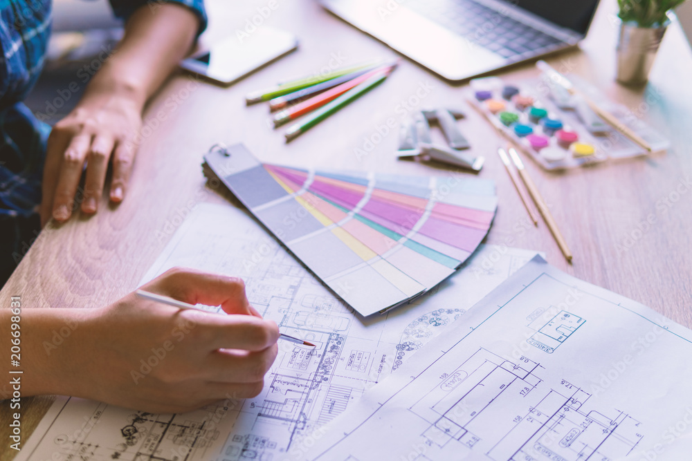 Interior designer designs make color on blueprint of house for present ...