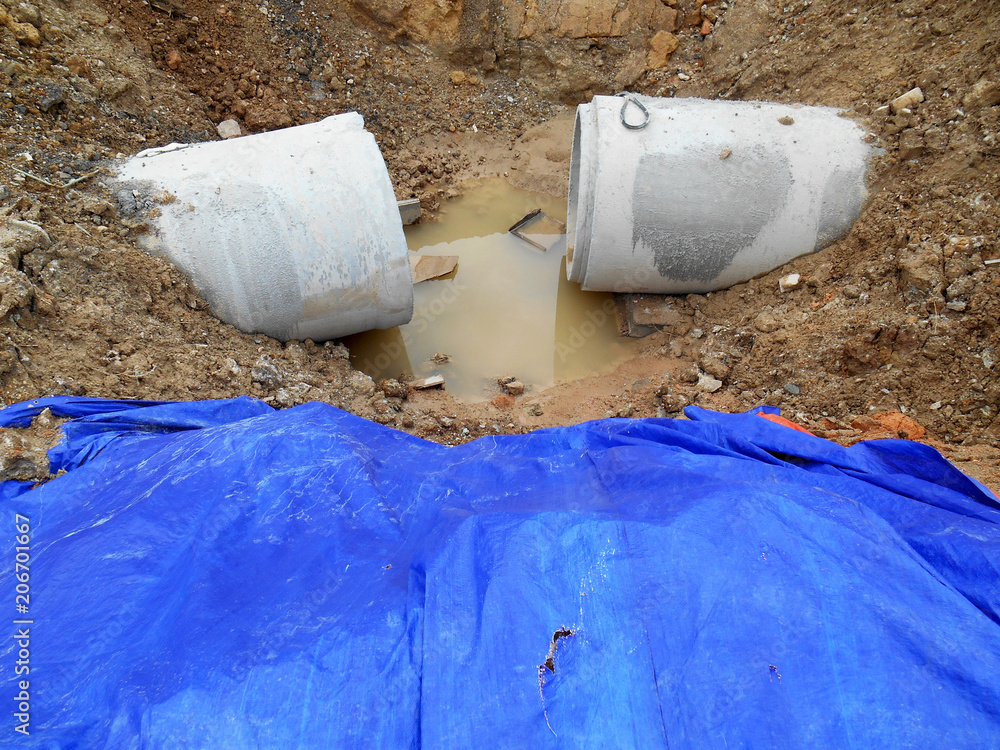 Underground drainage manhole under construction by construction workers ...