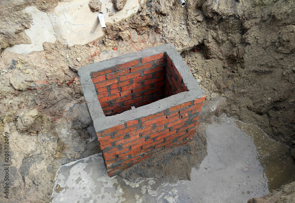 Underground drainage manhole under construction by construction workers ...