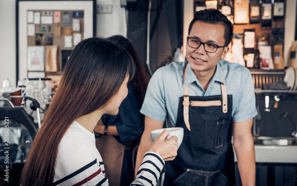 Male barista talking with customer about tasted of coffee cup with ...