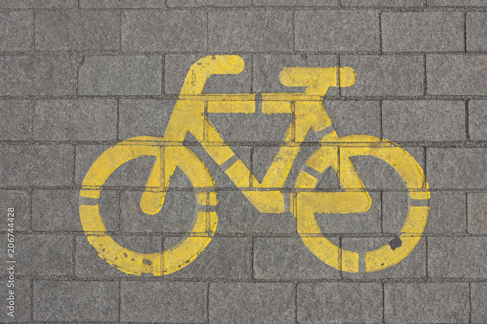 Yellow sign of a bicycle path drawn on the asphalt road. Lanes for ...