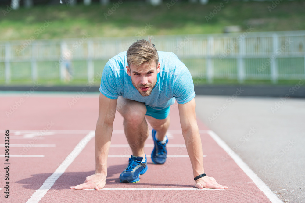 Man runner on start position at stadium. Runner in start pose on ...