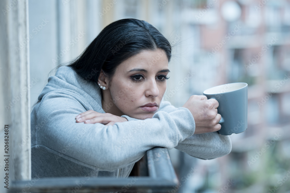 Young attractive sad woman suffering from depression drinking a cup of ...
