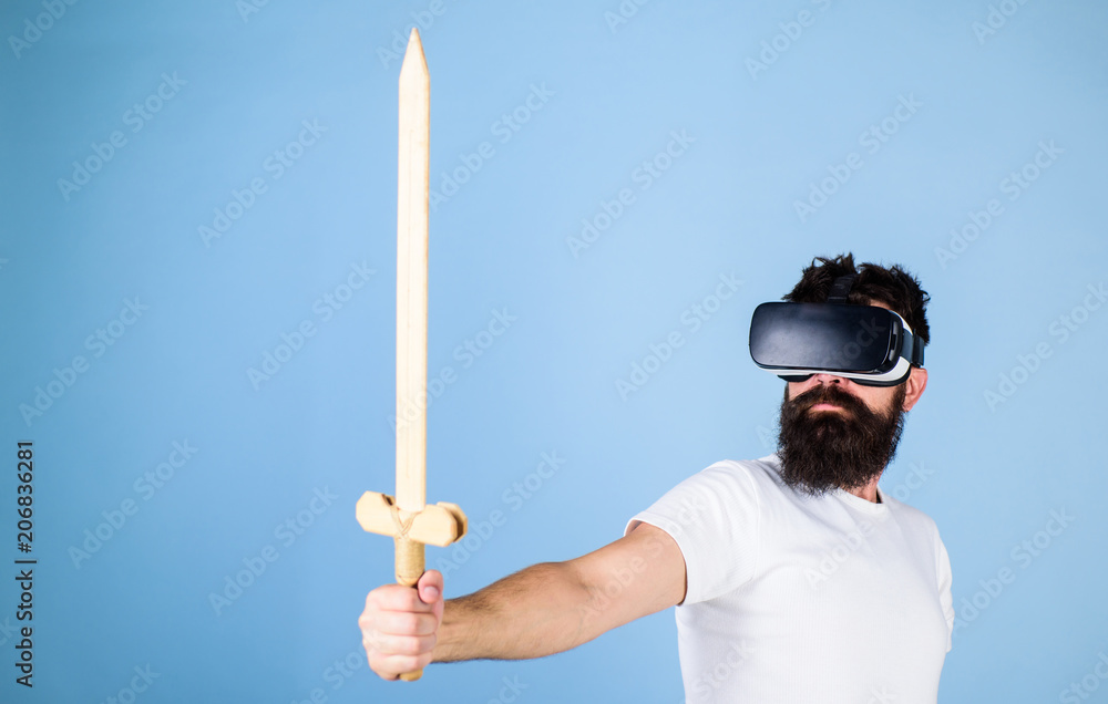 Gamer concept. Guy with head mounted display holds sword, play fighting ...