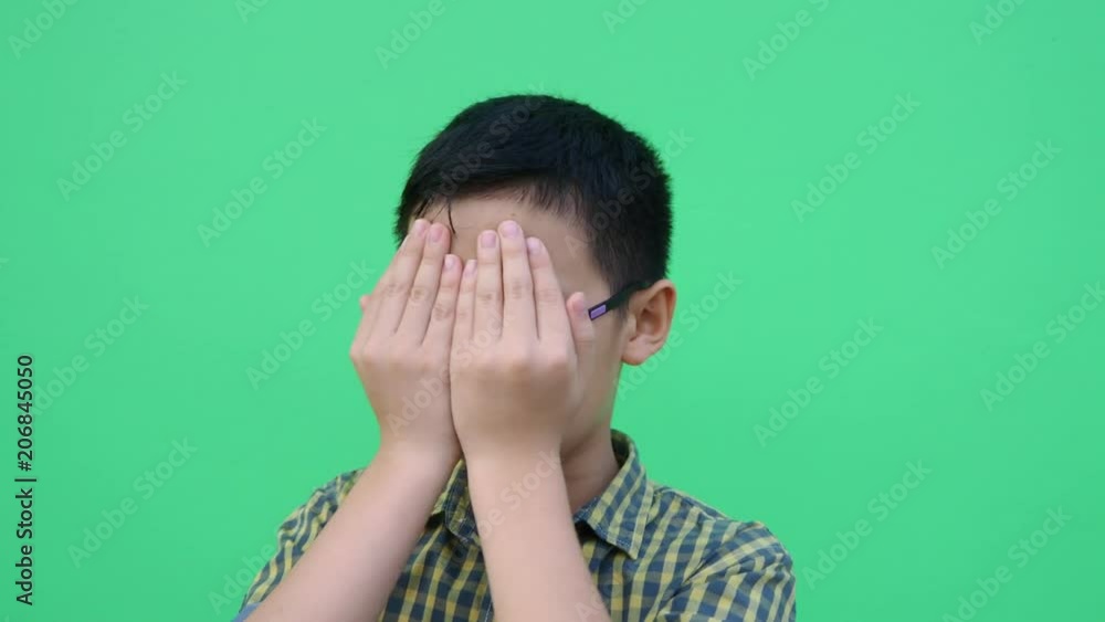 Young asian boy playing hide and seek, peak-a-boo, covering face by ...