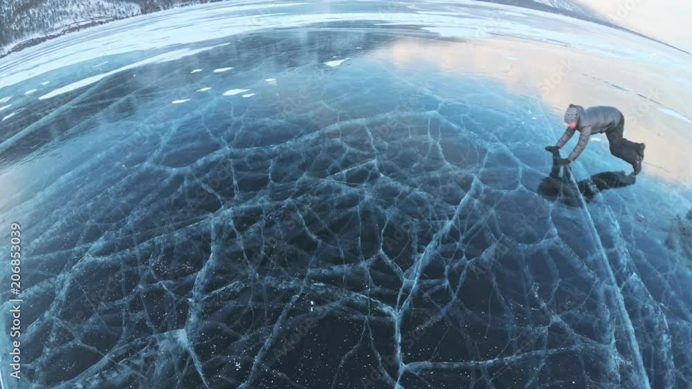 Family is having fun on beautiful ice in cracks. Father mother son and ...