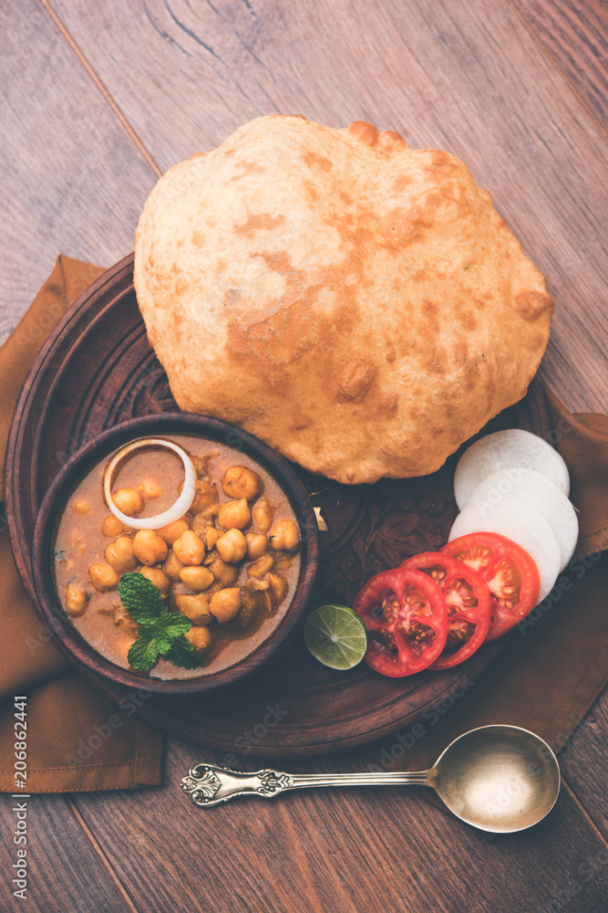 Chole Bhature or Chick pea curry and Fried Puri served in terracotta ...