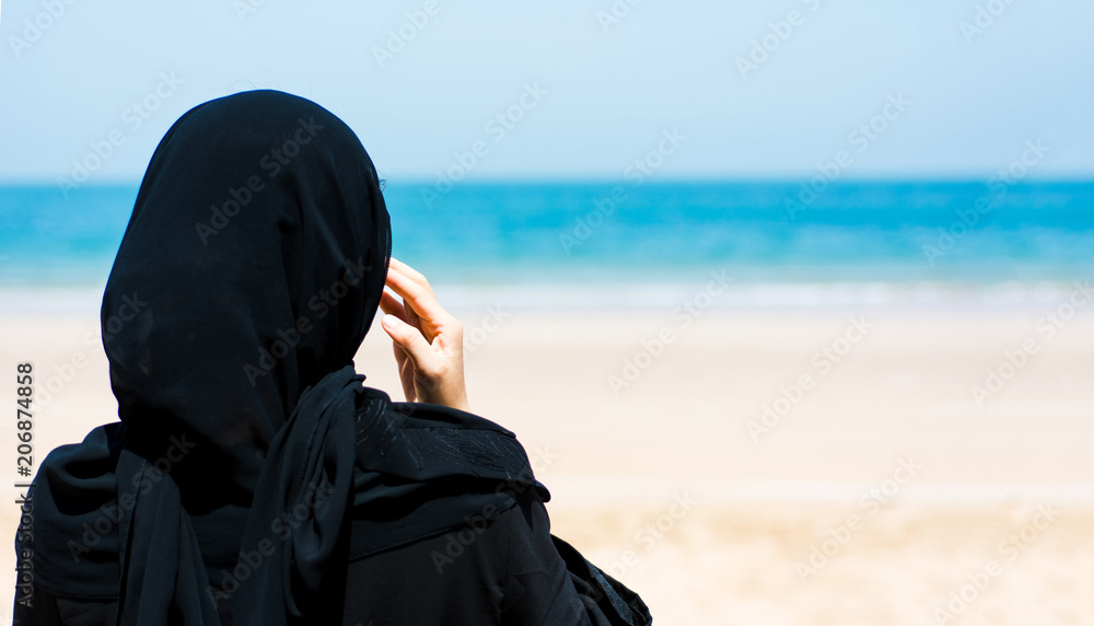 Muslim woman on the beach back view Stock Photo | Adobe Stock