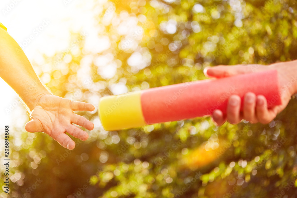 Staffelstab nehmen bei Staffellauf am Sportfest Stock Photo | Adobe Stock