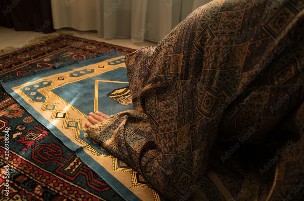 Muslim woman praying for Allah muslim god at room near window. Hands of ...