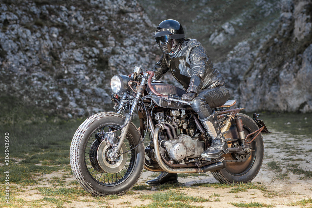Biker with black leather suit and mask stay on his custom special rat ...