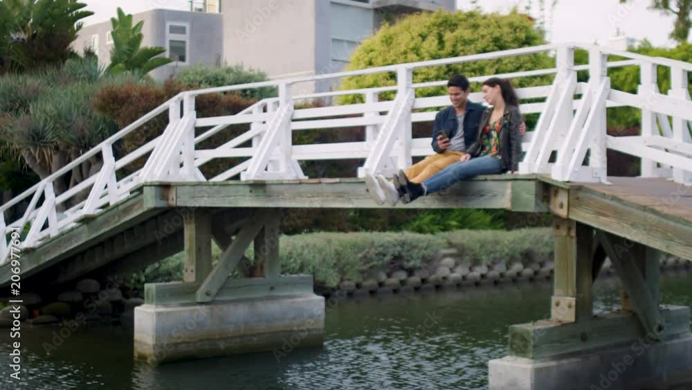 Vidéo Stock Cute Couple Sit On Bridge In Venice Beach Canals And Take ...
