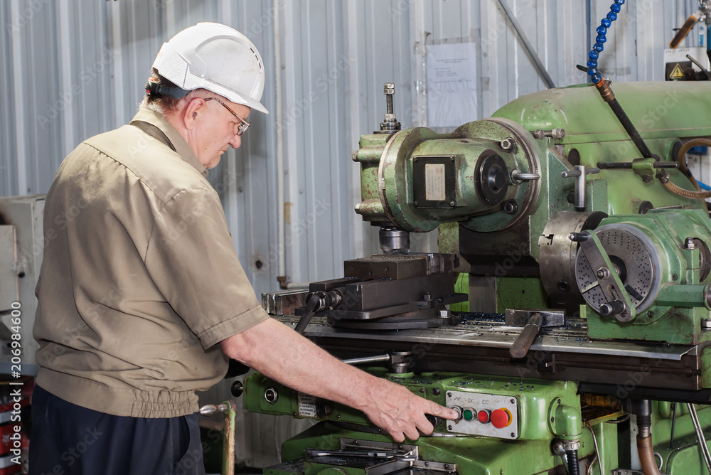 Old machinist working a metal lathe Stock Photo | Adobe Stock