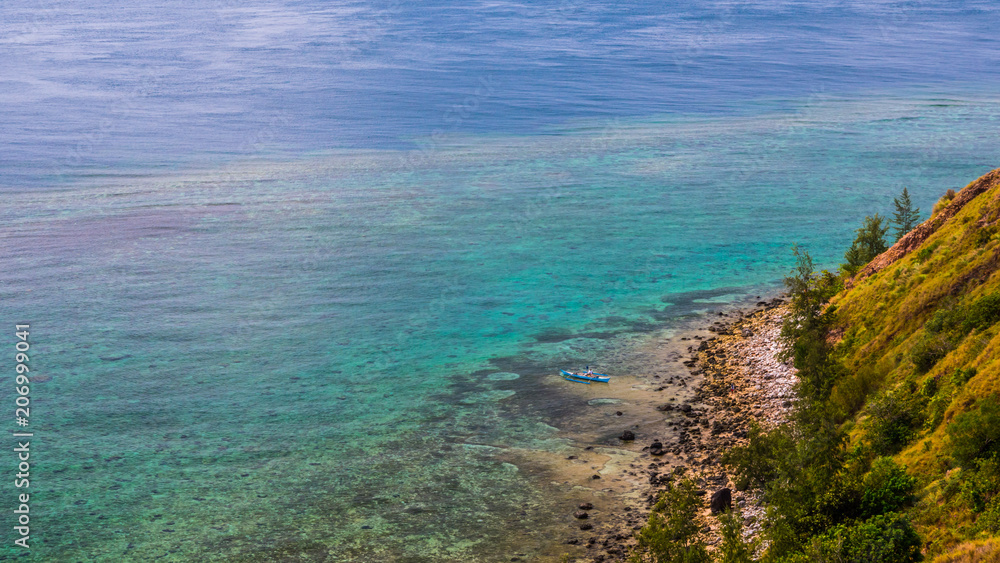 Blue ocean and a shore line with a boat in Mararison island, Philippine ...