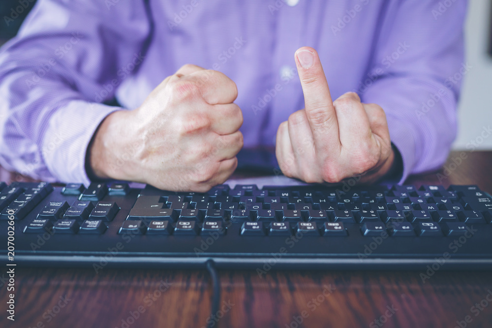 Agression in the Internet, man sitting behind keyboard with hand ...
