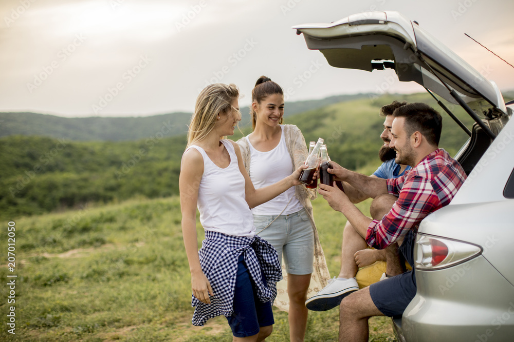 Young people sitting in the car trank Stock Photo | Adobe Stock