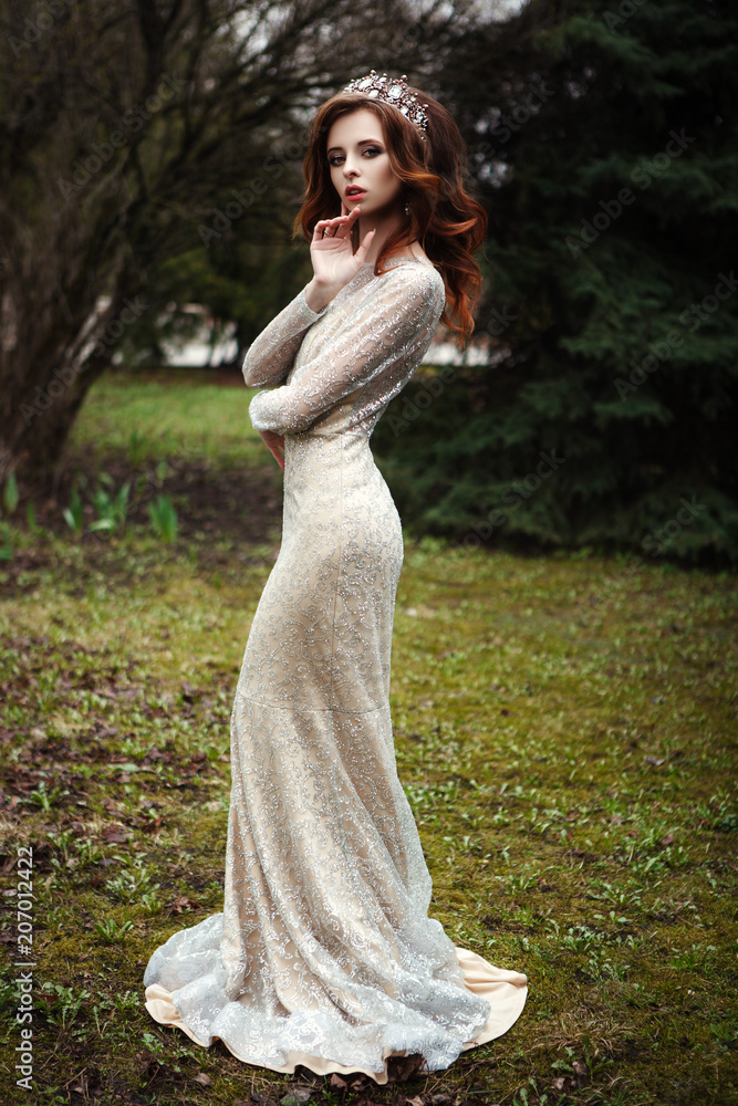 Beautiful model wearing glamour golden dress and crown is posing in the ...