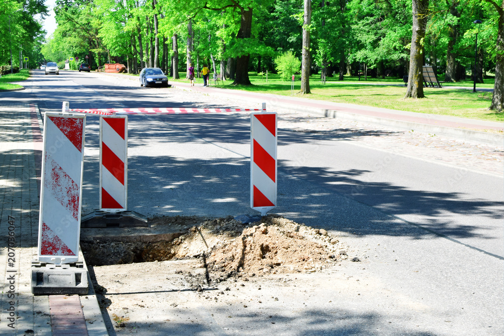 Big pit on road and traffic warning signs. Stock Photo | Adobe Stock