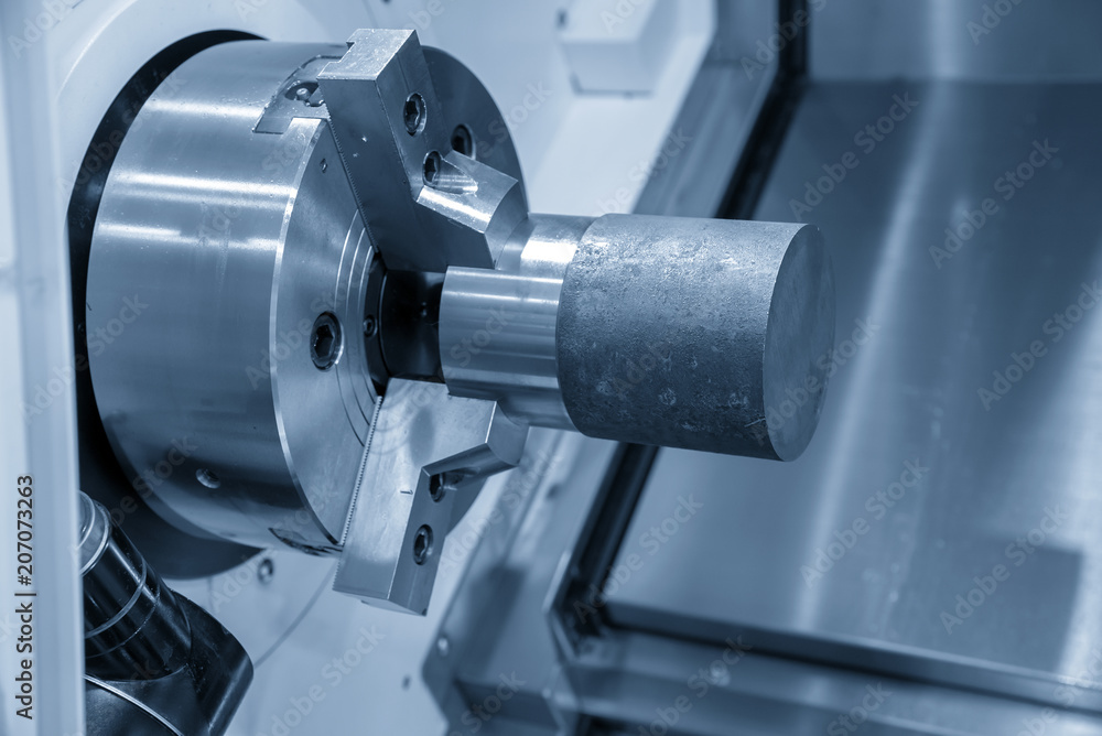 The CNC lathe or turing machine cutting the raw material in the light ...