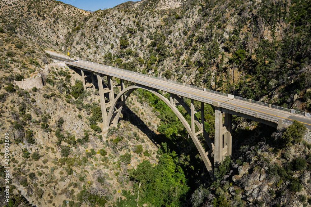 Long span of an arch bridge above a wooded valley in the Angeles ...