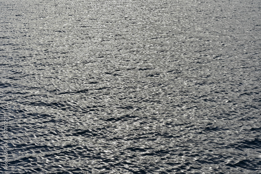 Foto de Sea surface covered with tiny choppy waves reflecting silver ...
