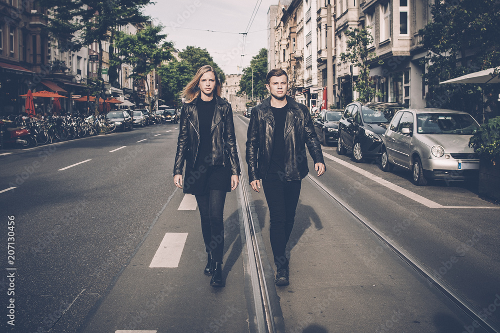 Young couple wearing black matching clothes walking side by side on the ...