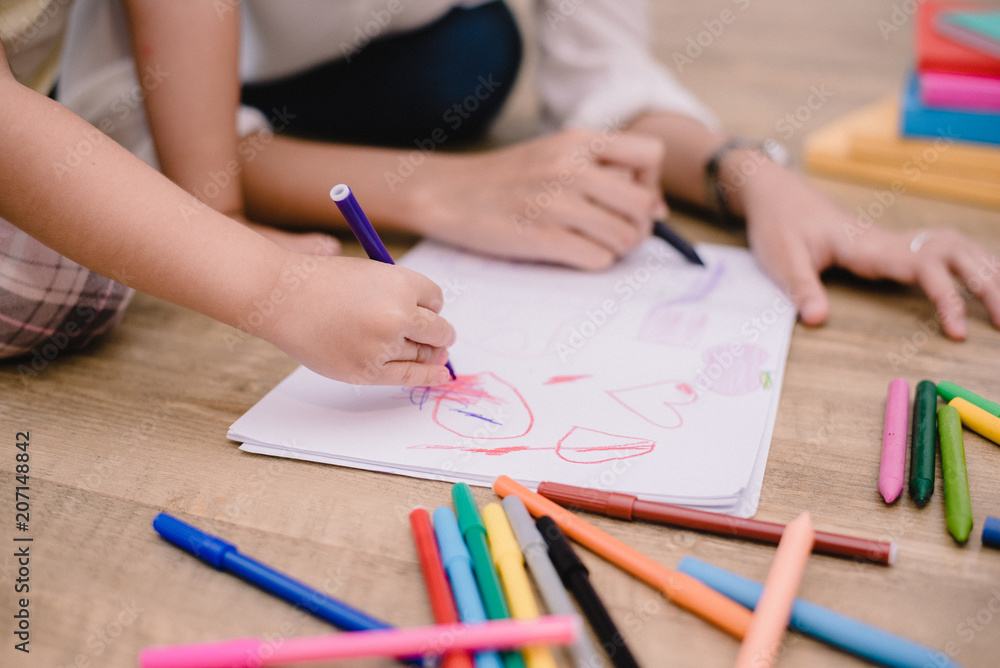 Closed up hands of mom teaching little children to drawing cartoon in ...