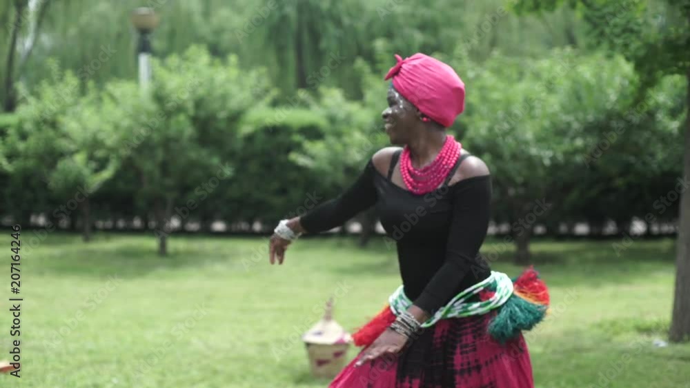 African women are dancing a folk traditional dance on a grass meadow ...