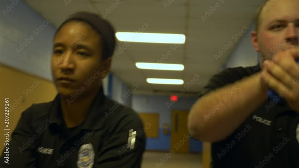 A squad of police clear rooms in a school with guns drawn to train for ...