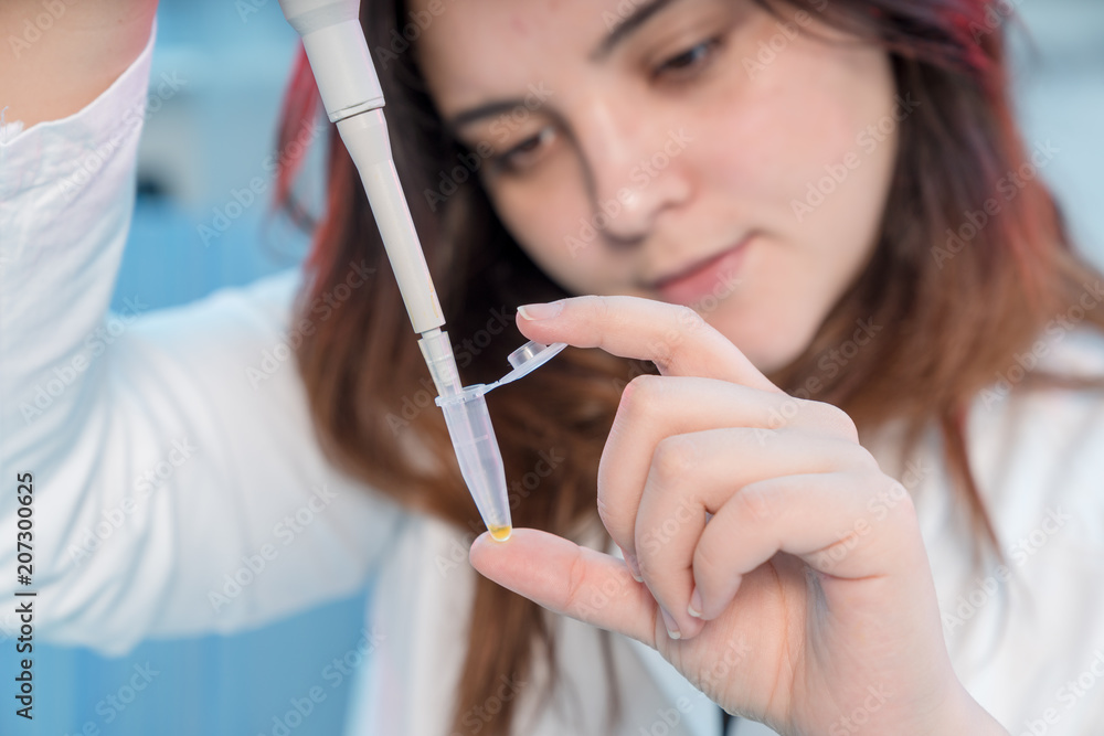 Woman technician with multipipette in genetic laboratory PCR research ...