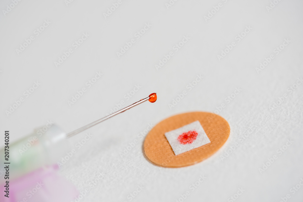 Drop of red liquid on an injection needle Stock Photo | Adobe Stock