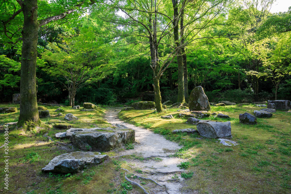 Curved dirt path leading through mysterious stone formation into the ...